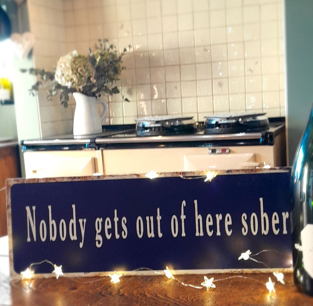 Novelty metal sign with message 'Nobody gets out of here sober'